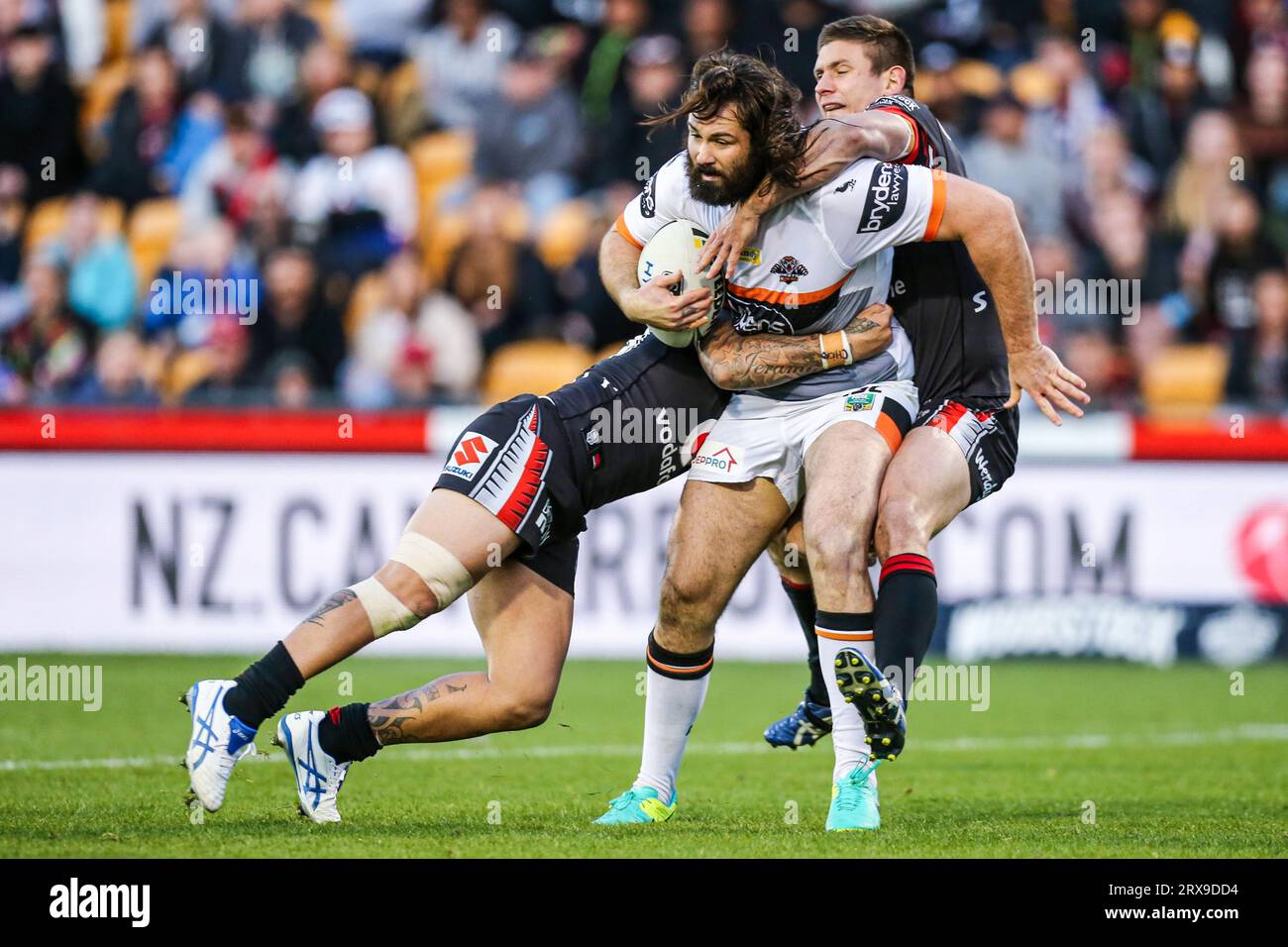 Captain Aaron Woods of the Wests Tigers is tackled by Jacob Lillyman of ...