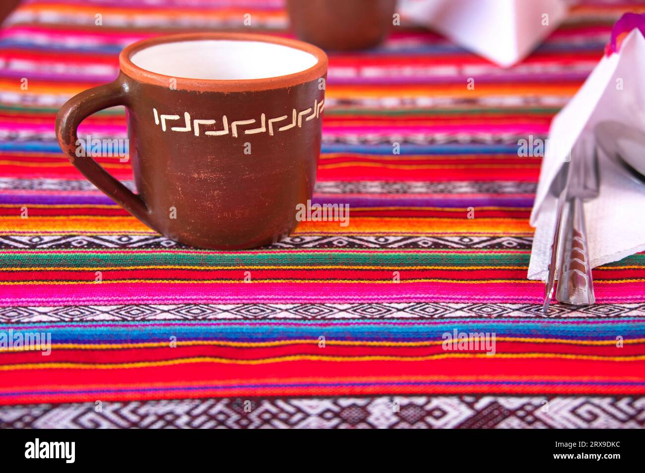 Handmade traditional clay cup on embroidered tablecloth in Peruvian ...