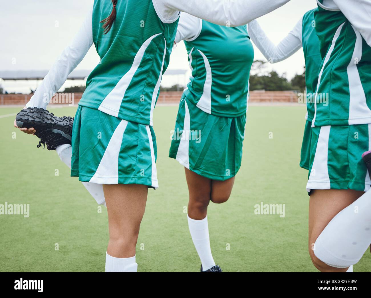 Team, stretching legs and warm up on field, sports and uniform for ...