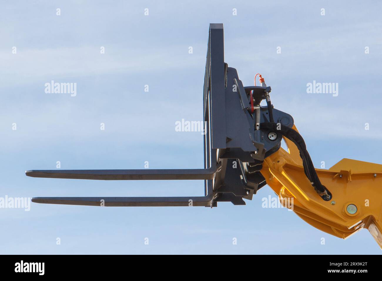 Part and detail of forklift loader or stacker on blue sky background ...