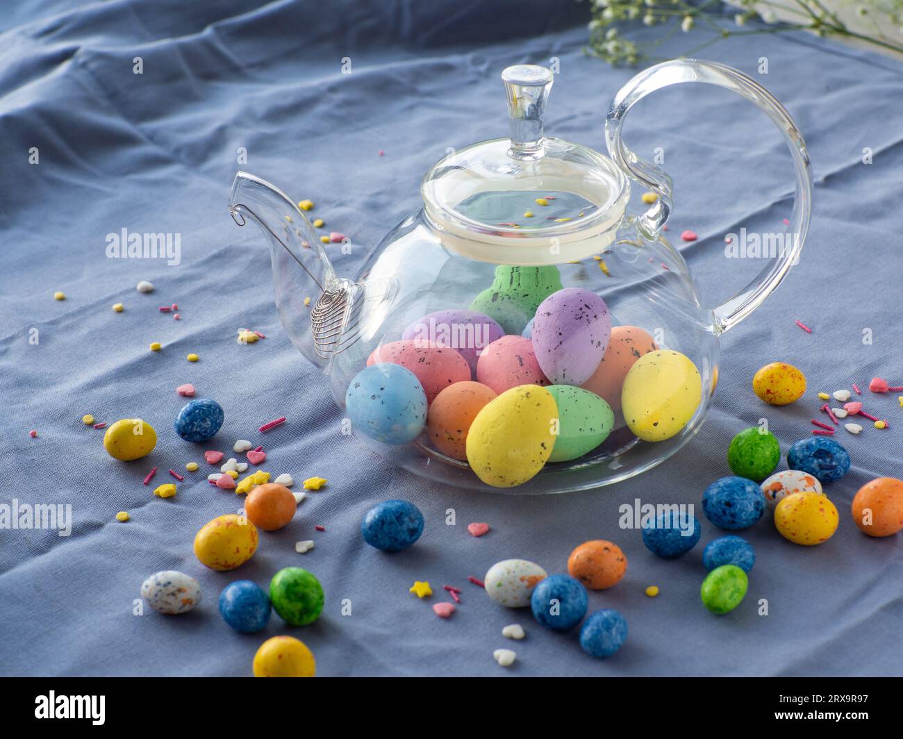Composition with easter eggs in glass teapot surrounded by small ...