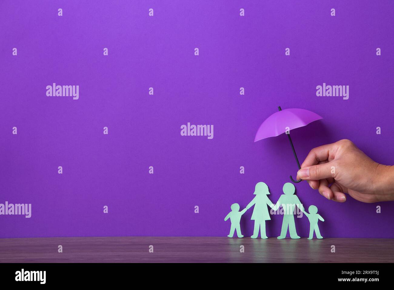 Hand holding a small purple umbrella. Insurance Concept Stock Photo - Alamy