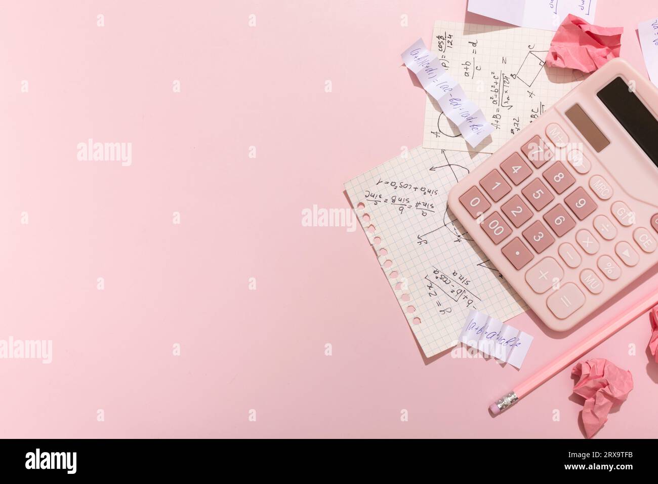 On a pink background, a scribbler, a calculator, a pencil, school ...