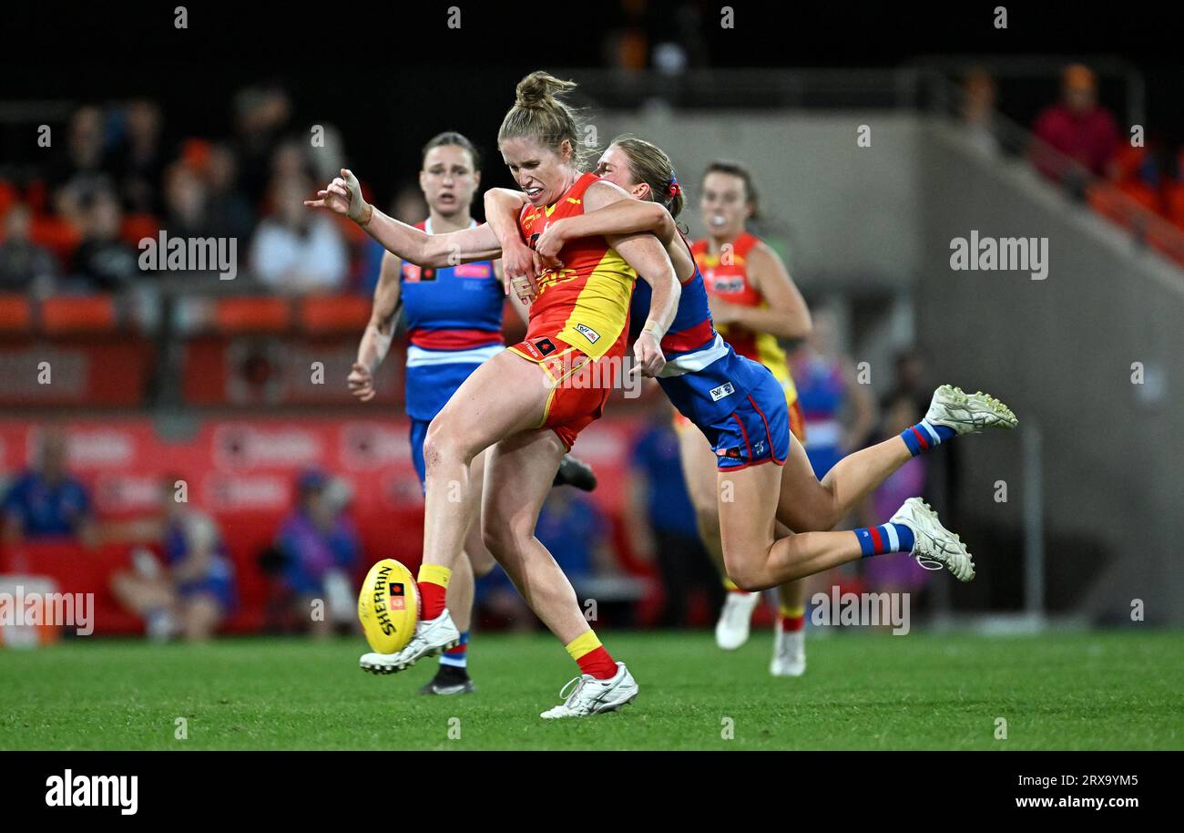 Tara Bohanna of the Suns kicks a goal while being tackled by Isabella ...