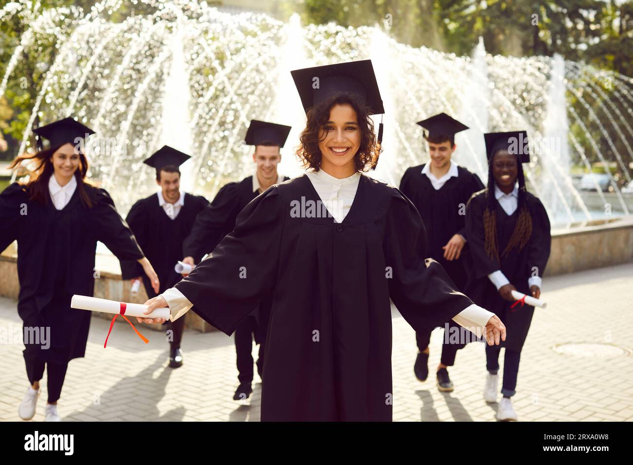 Young smiling joyful girl student in a university graduate gown and ...