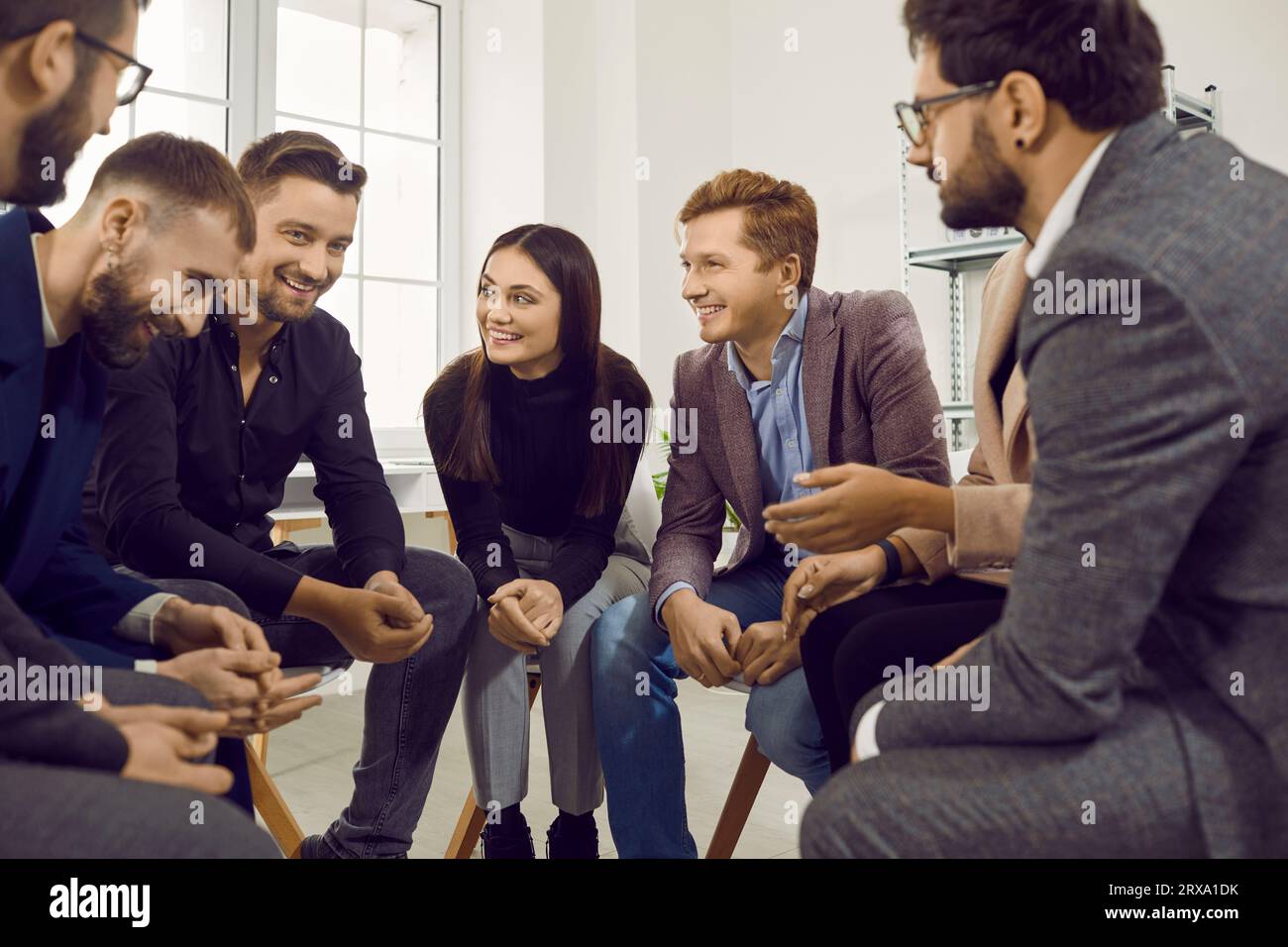 Office colleagues having informal conversation during meeting in modern ...