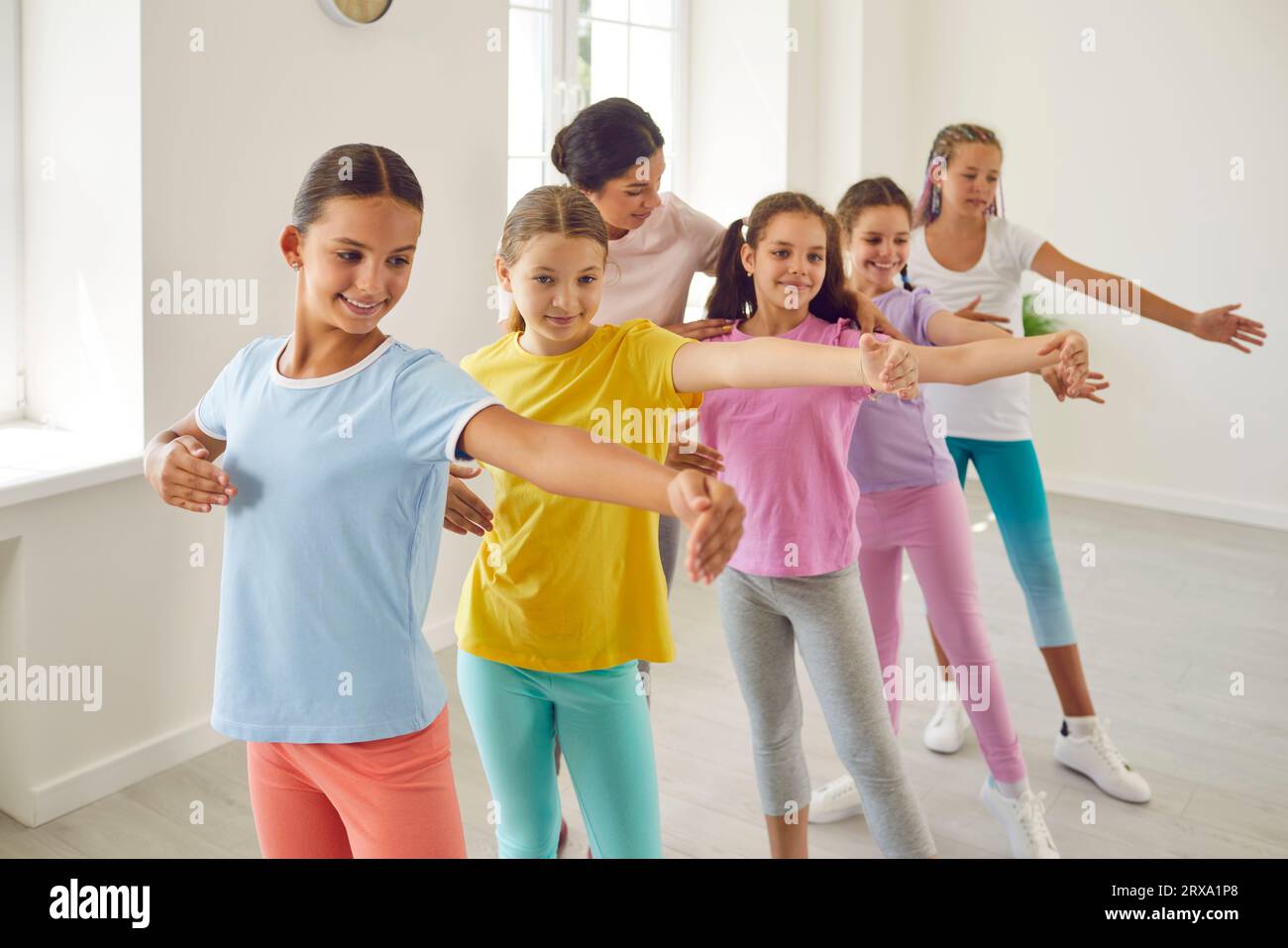 Woman choreographer helping her students girls in doing a dance ...