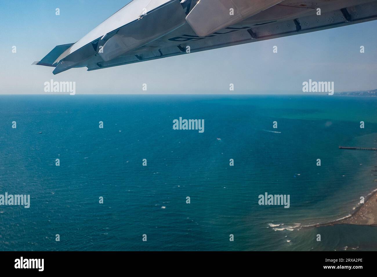 Azure waves of the sea under the wing of a flying plane Stock Photo - Alamy
