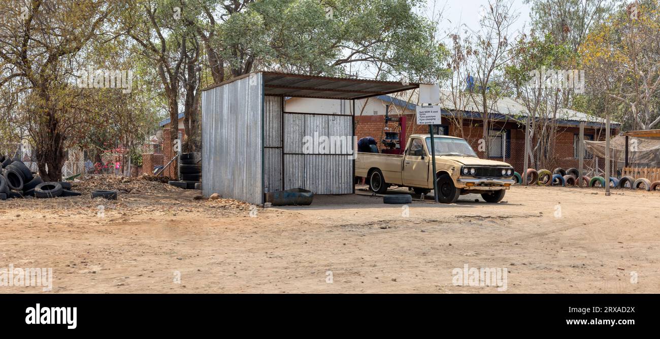 african township an empty shack of a street vendor repairing tires on ...