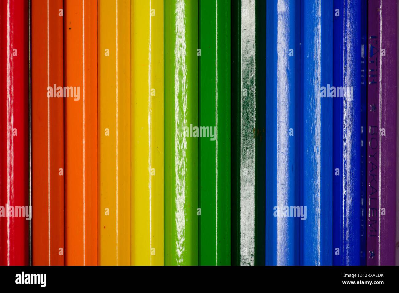 A photo of colorful pencils lined up, ends unseen, showcasing a continuous flow of vibrant hues ...
