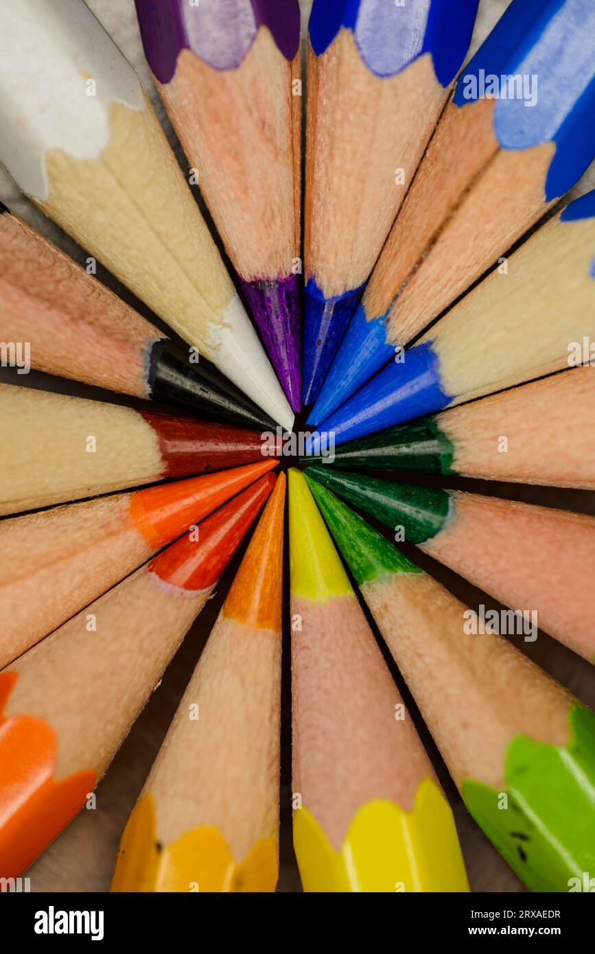 Vibrant colored pencils arranged in a circle, tips meeting in the center, showcasing a spectrum ...