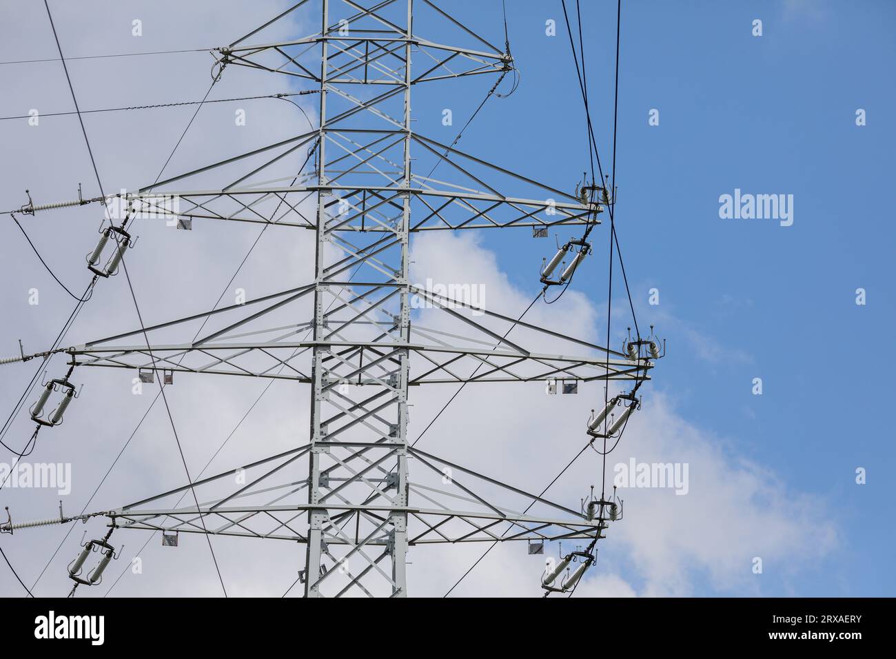 A high voltage elenctic line pole against a sky with white clouds Stock ...