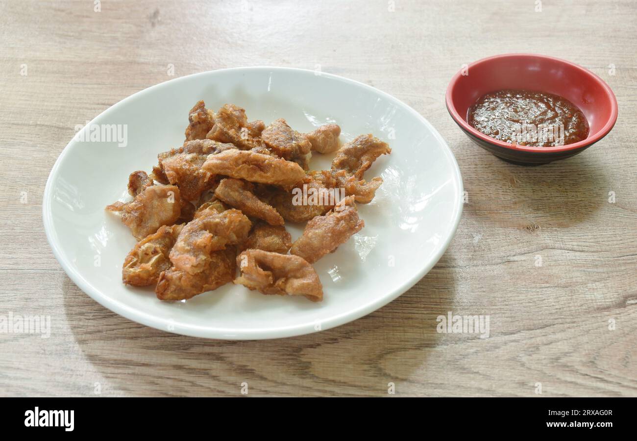 crispy fried pork innards with flour on plate dipping with spicy ...