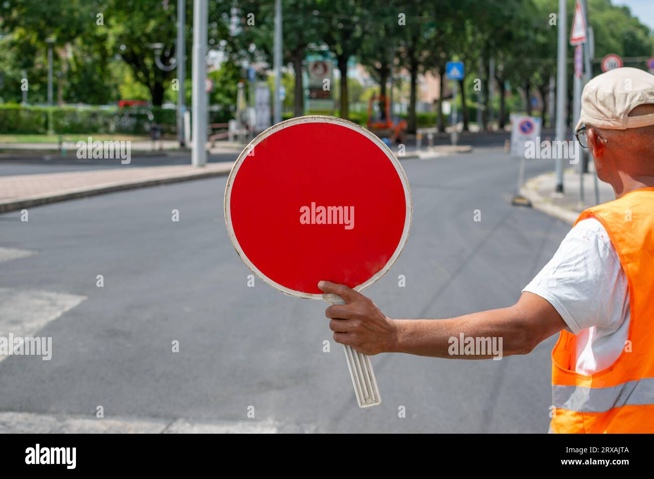 Construction worker holding a Red Stop Sign and directing traffic on ...