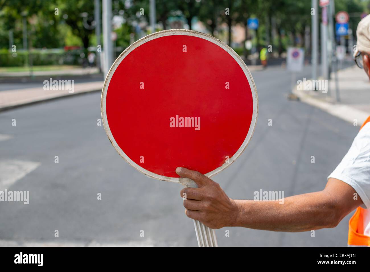 Construction worker holding a Red Stop Sign and directing traffic on ...