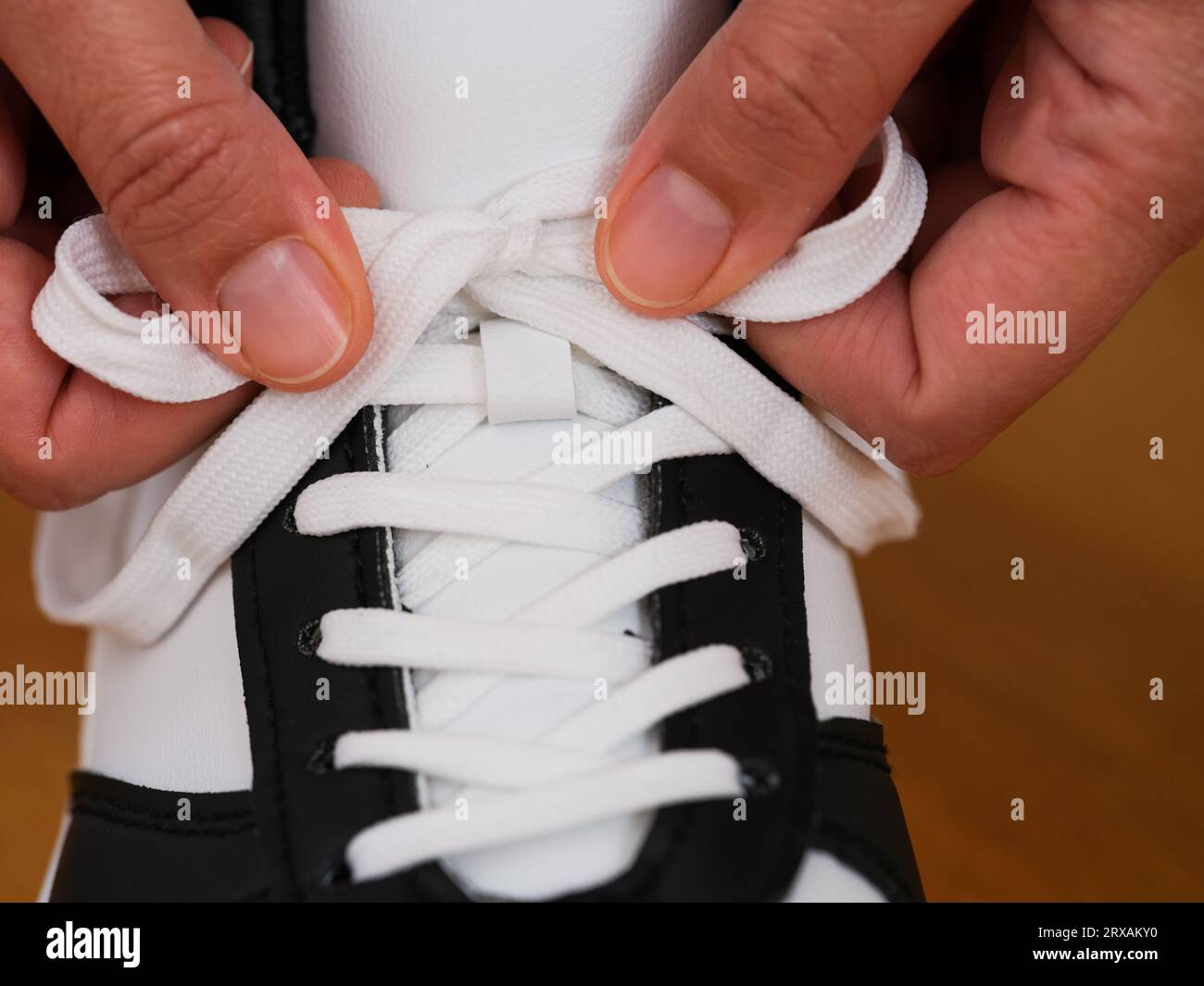 Person tying white sneakers hi-res stock photography and images - Alamy