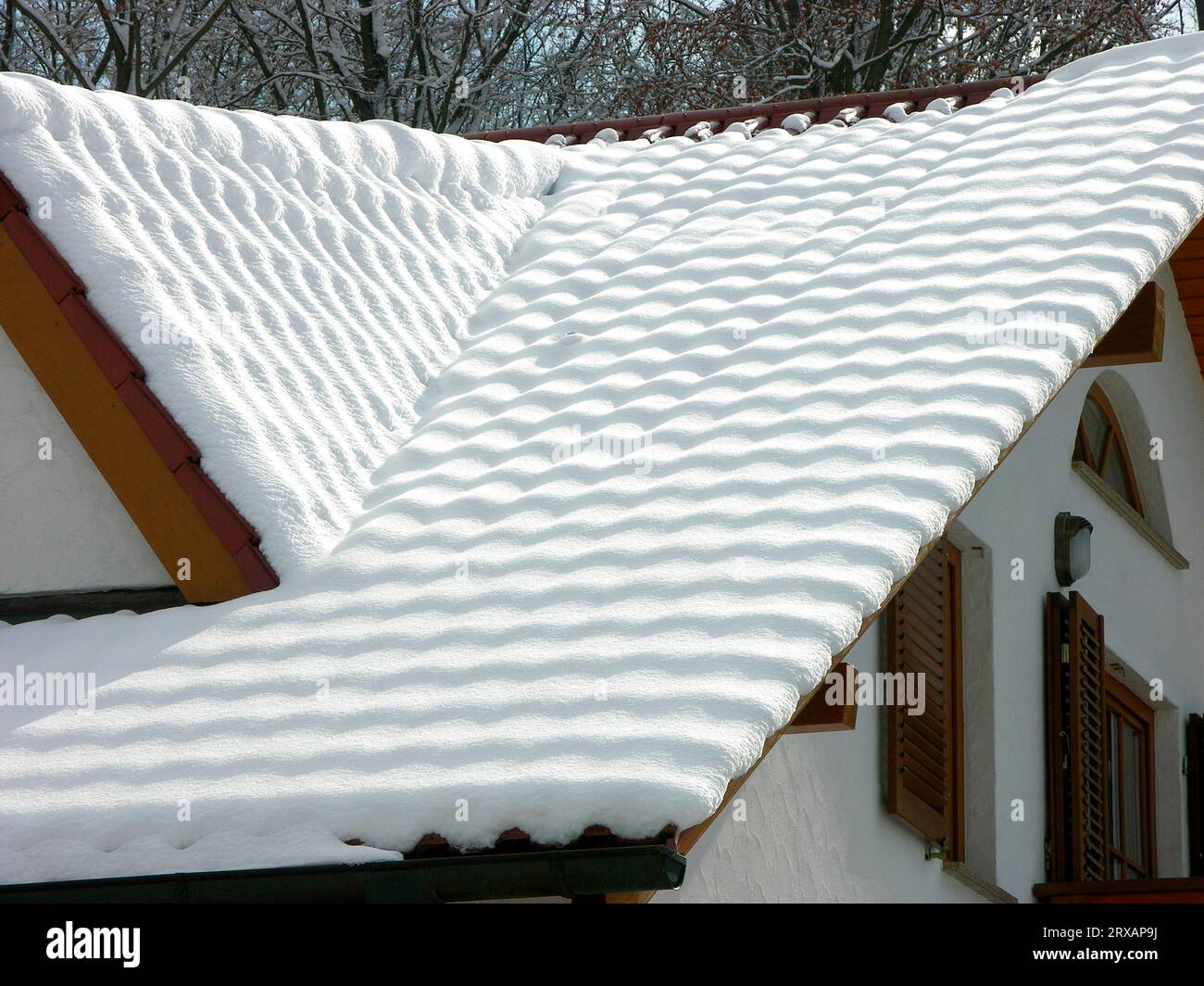 Snow-covered tiled roof Stock Photo - Alamy