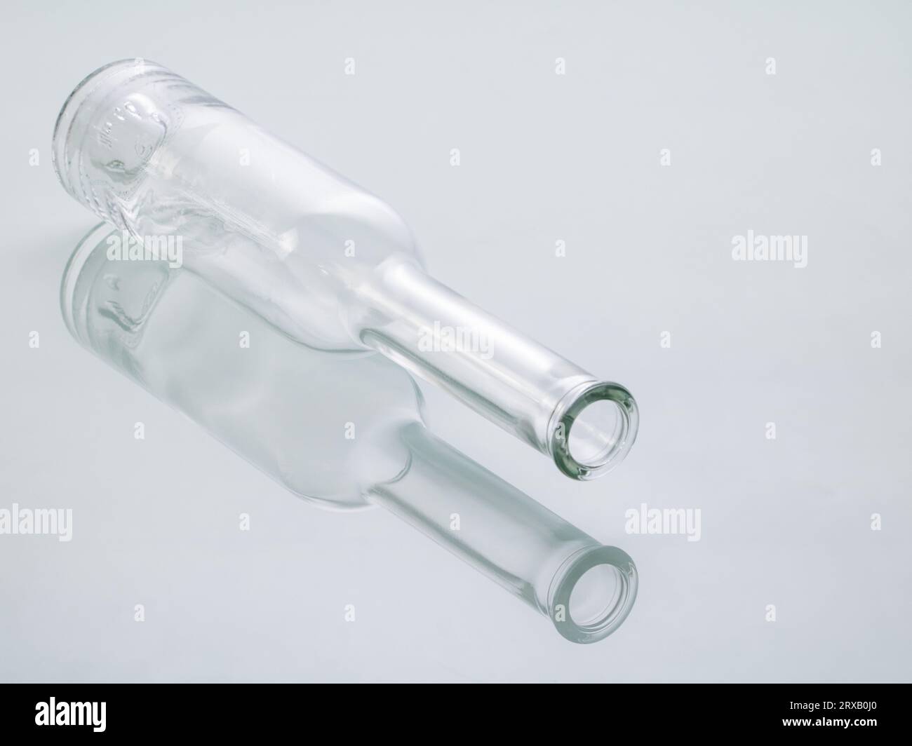 A transparent glass bottle lying on its side is beautifully reflected ...