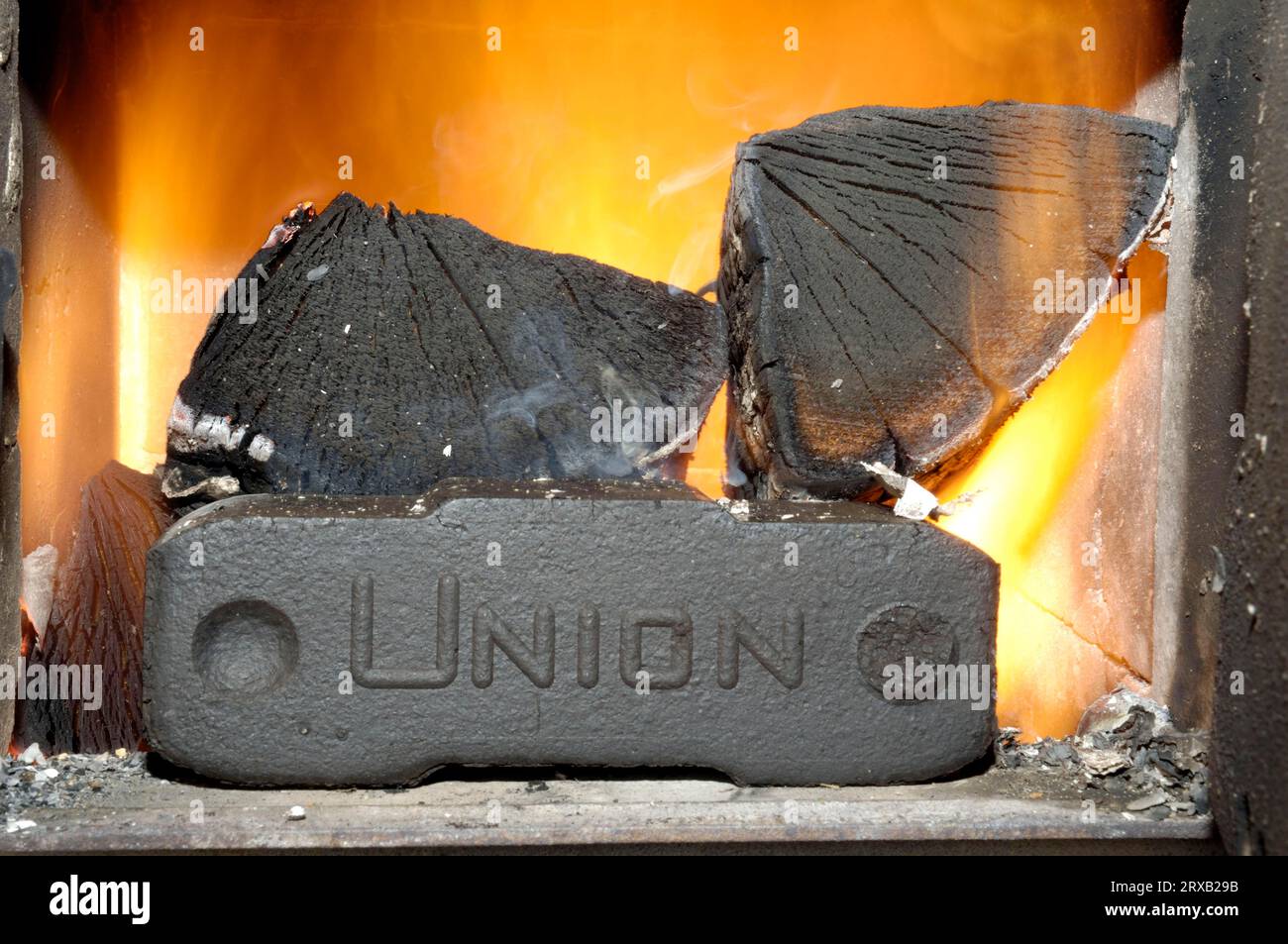 Burning logs and lignite briquette in stove, fossil fuels, heating ...