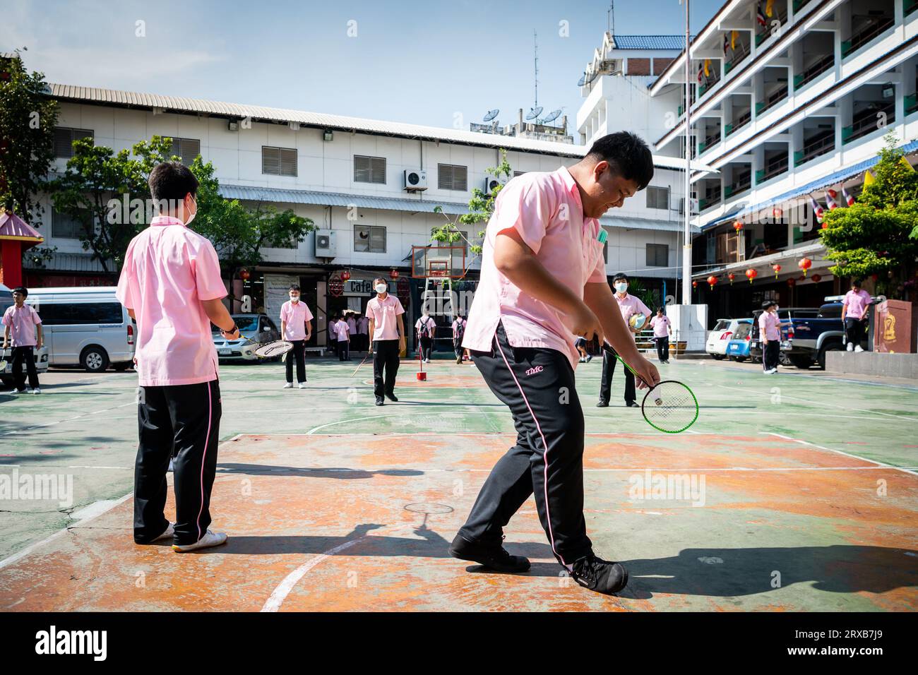 Young Thai school boys play badminton at their school Traimit ...