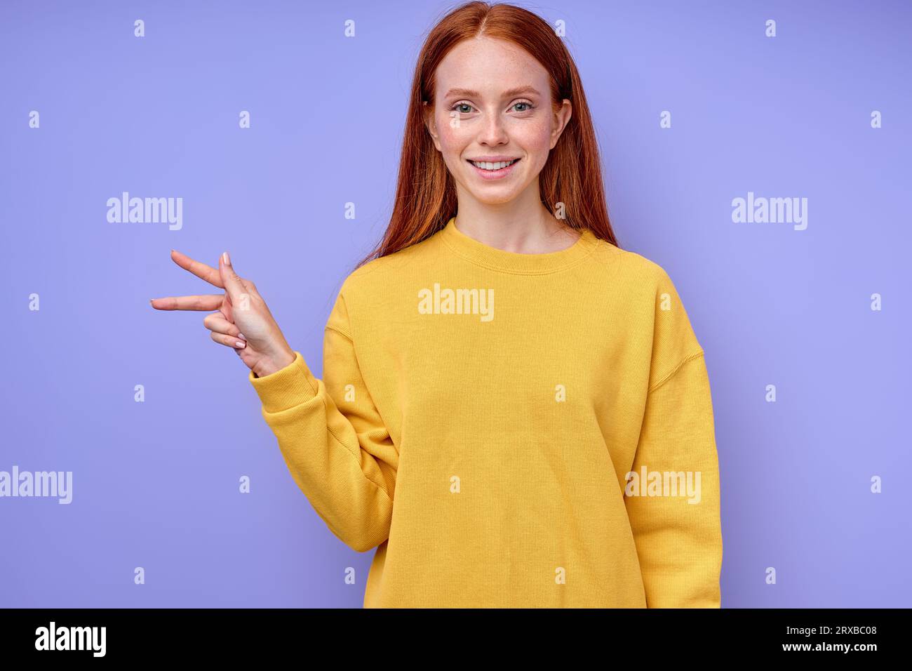 beautiful happy redhead woman in yellow stylish sweater demonstrating ...
