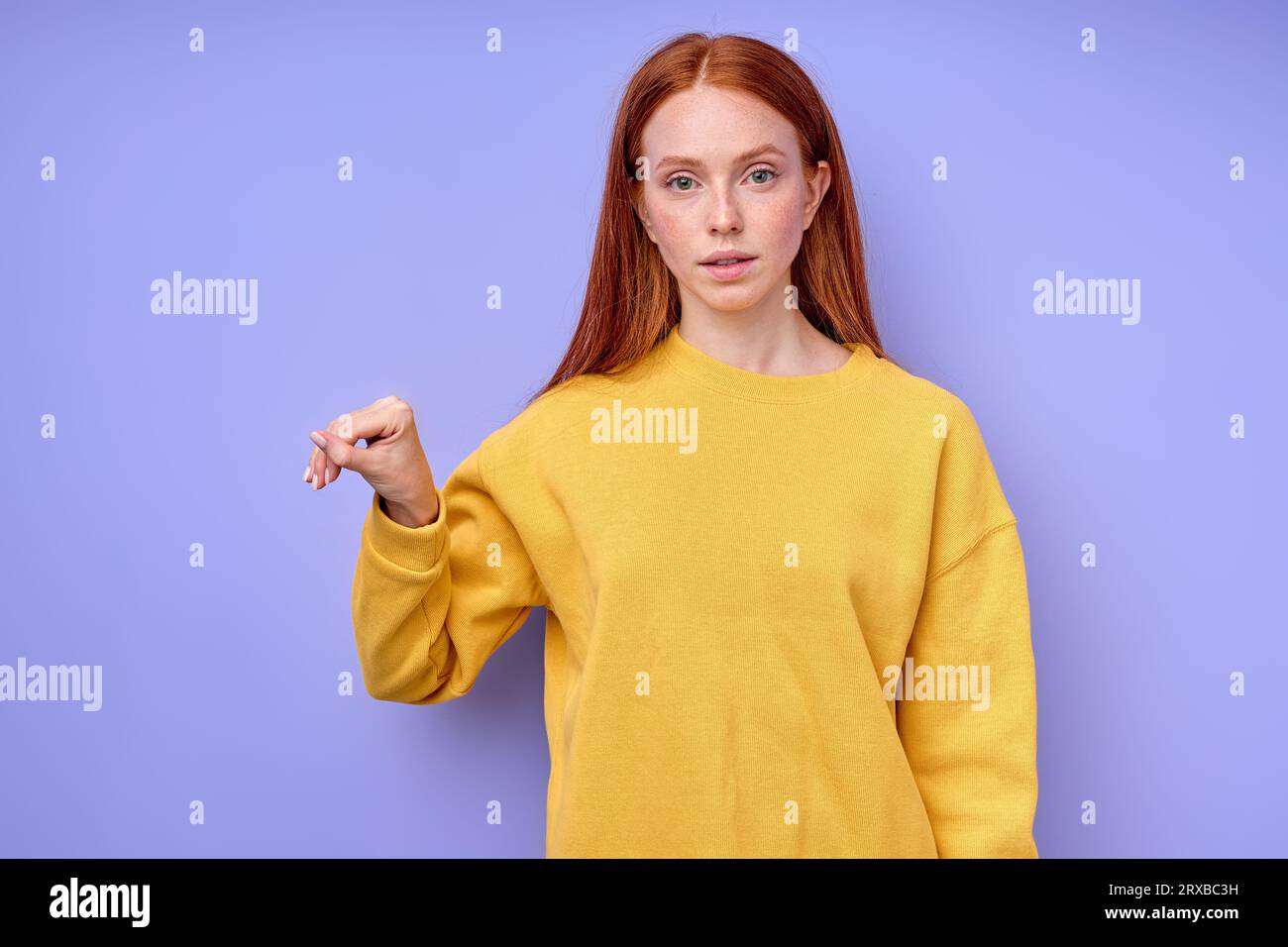 Indoor Photo Of Young Serious Ginger Lady In Casual Clothes Keeping Hand Raised While Learning