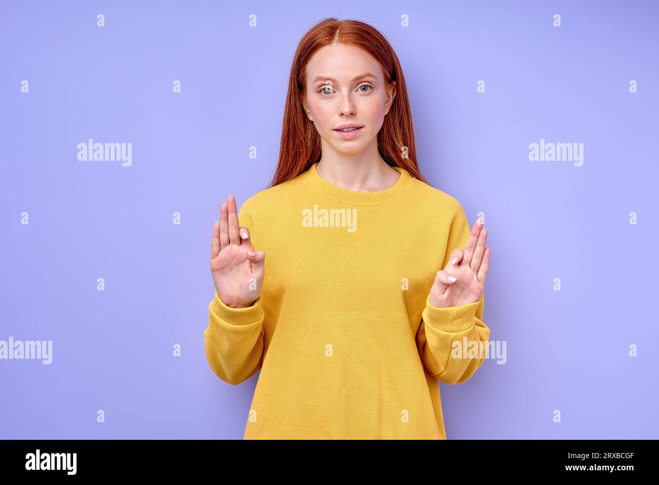 young good-looking ginger girl learning body language, isolated blue ...