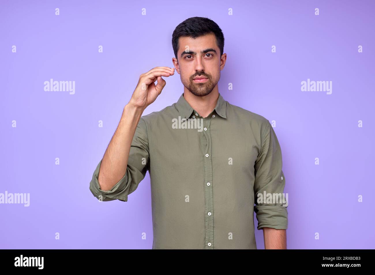 serious confident bearded man in green shirt demonstrating letter D ...