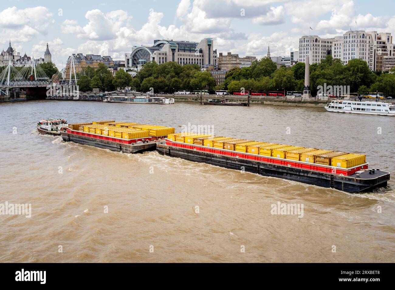 A Thames tug boat tows container barges on River Thames in central ...