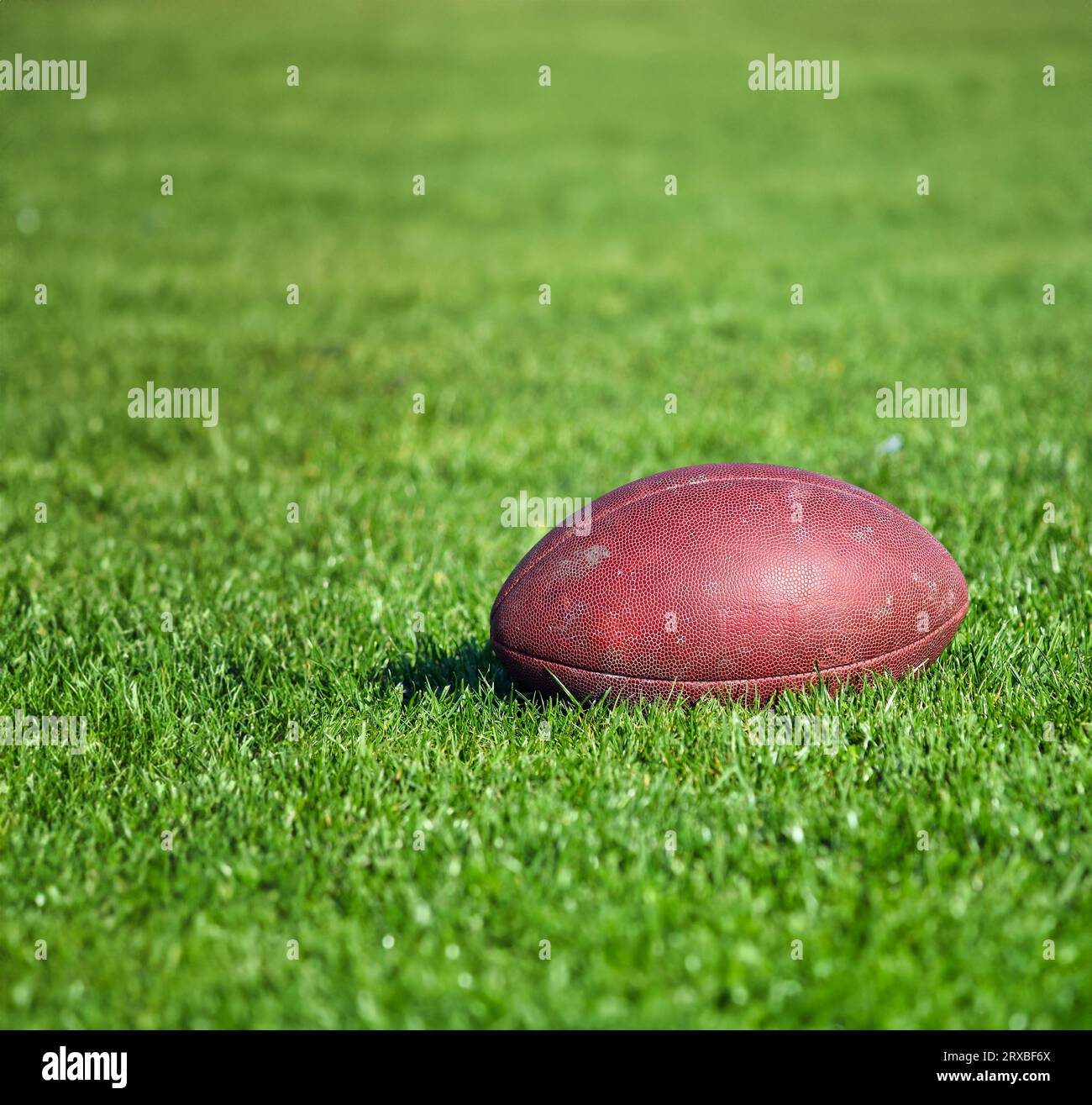 old American football ball on green grass sport Stock Photo - Alamy