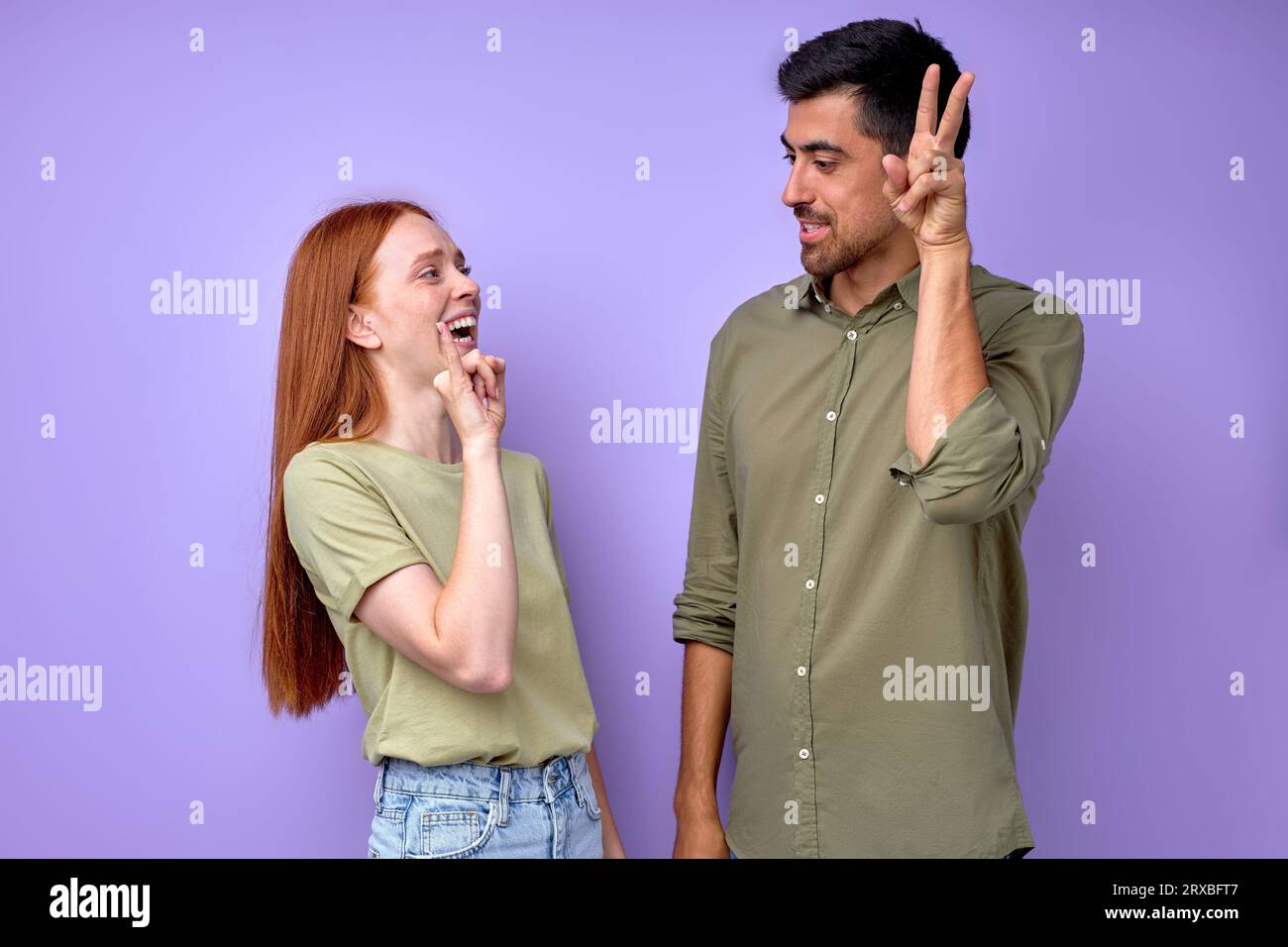 Young cheerful happy deaf mute couple using sign language on blue ...