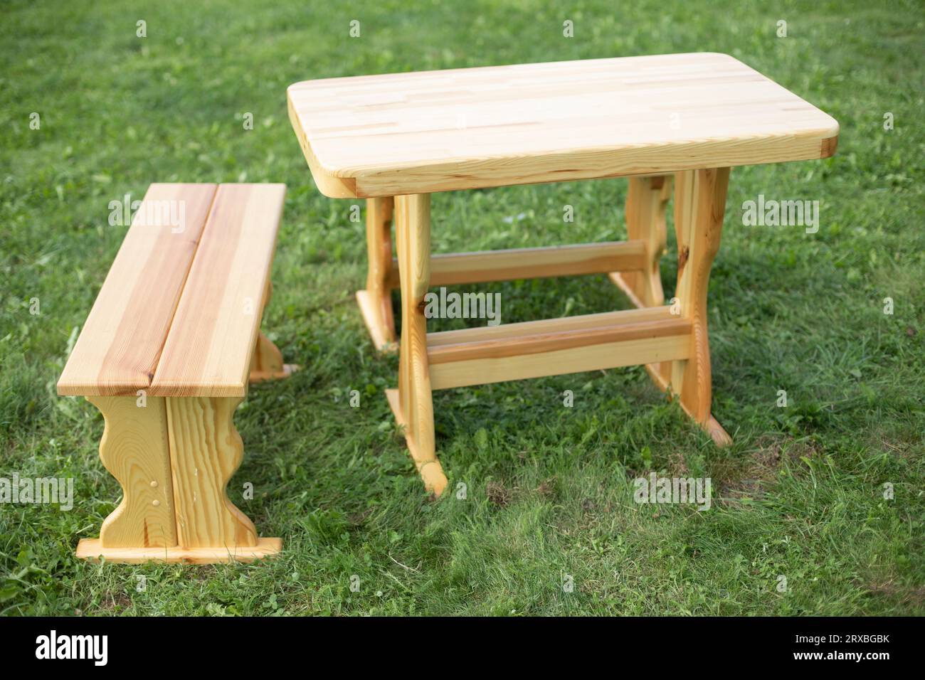 Table made of wood on green grass. Bench and table. Empty picnic area ...