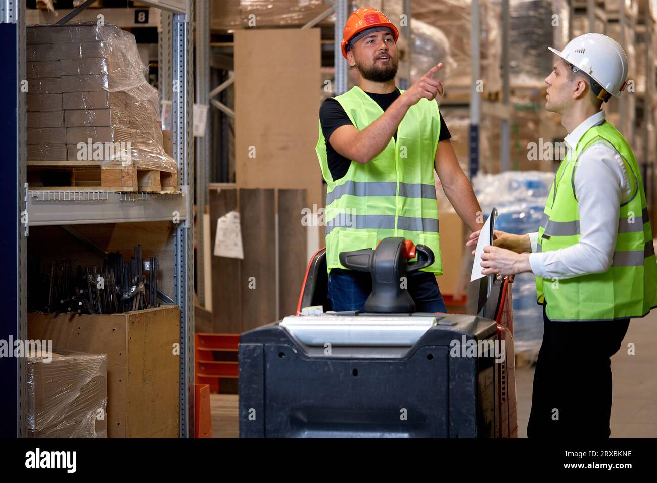 Young caucasian men workers doing stocktaking of products on shelves in ...