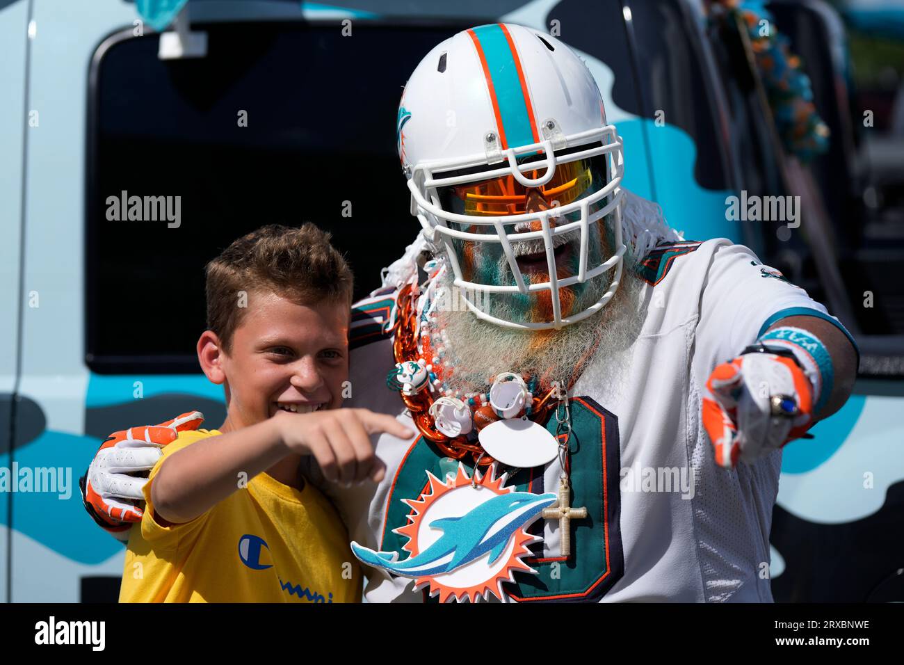 Roger Avila, known as "Dolfan Maniac" poses with a young fan before an NFL football game against ...