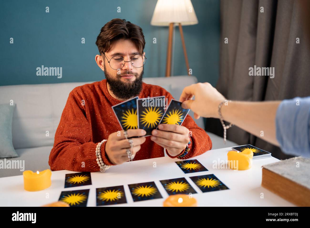 man fortune teller holding tarot cards in his hands and another man ...