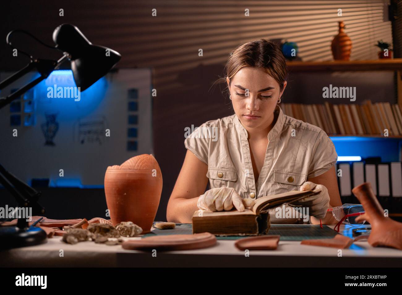 Female archeologist work late night in office research ancient ...
