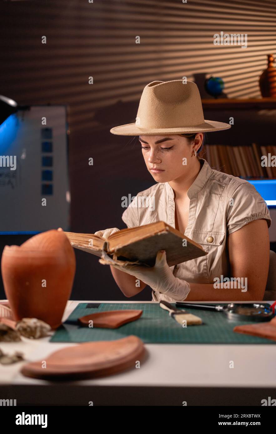 Female archeologist work late night in office research ancient ...