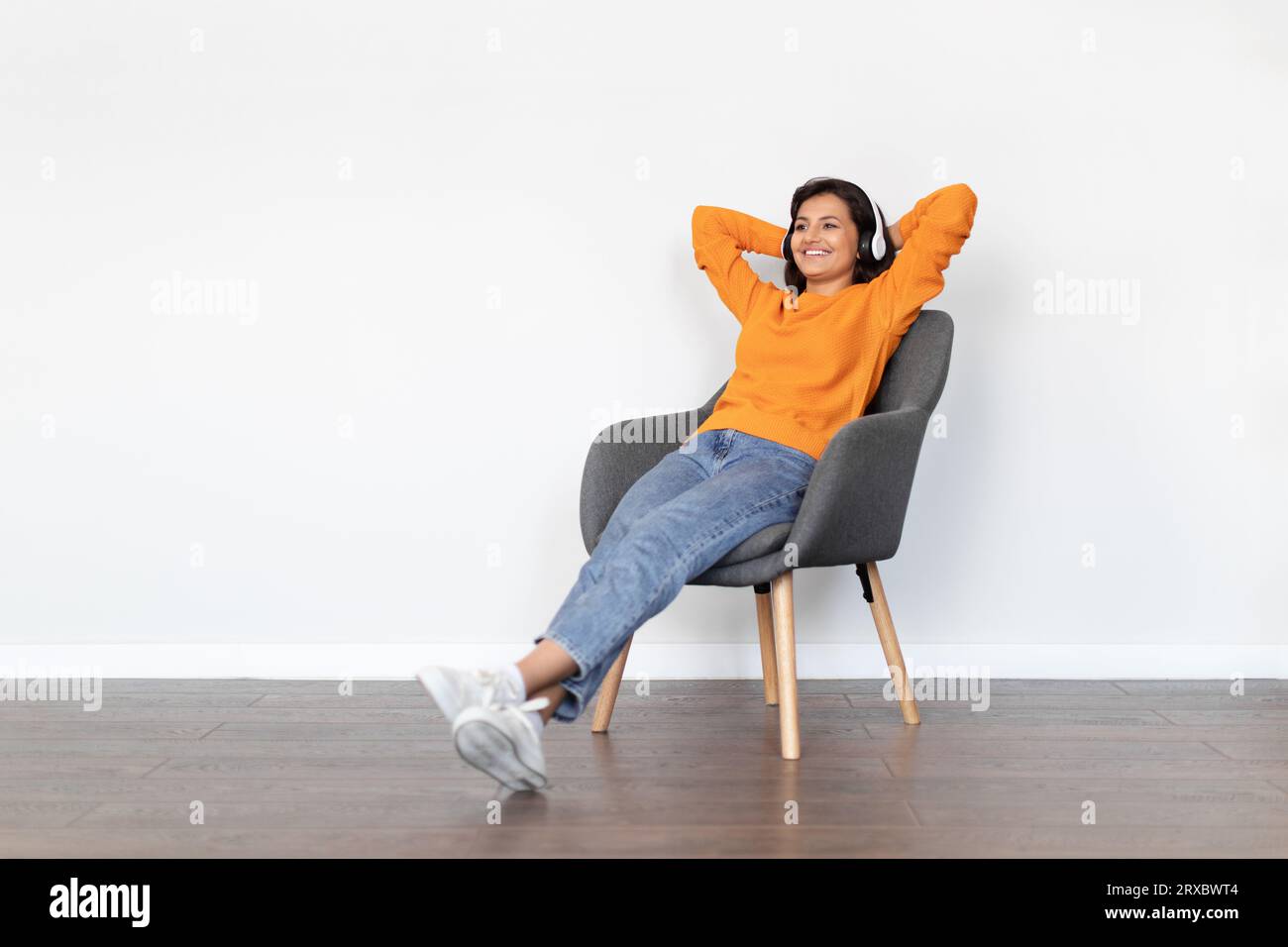 Relaxed young indian woman reclining on chair, listening to music Stock ...