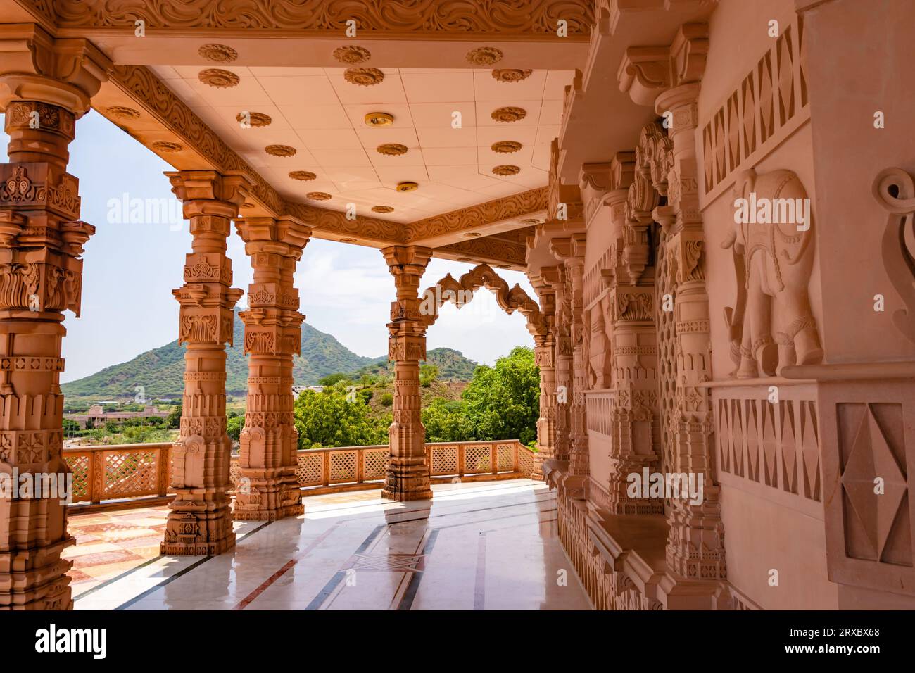 artistic hand carved red stone jain temple at morning from unique angle ...