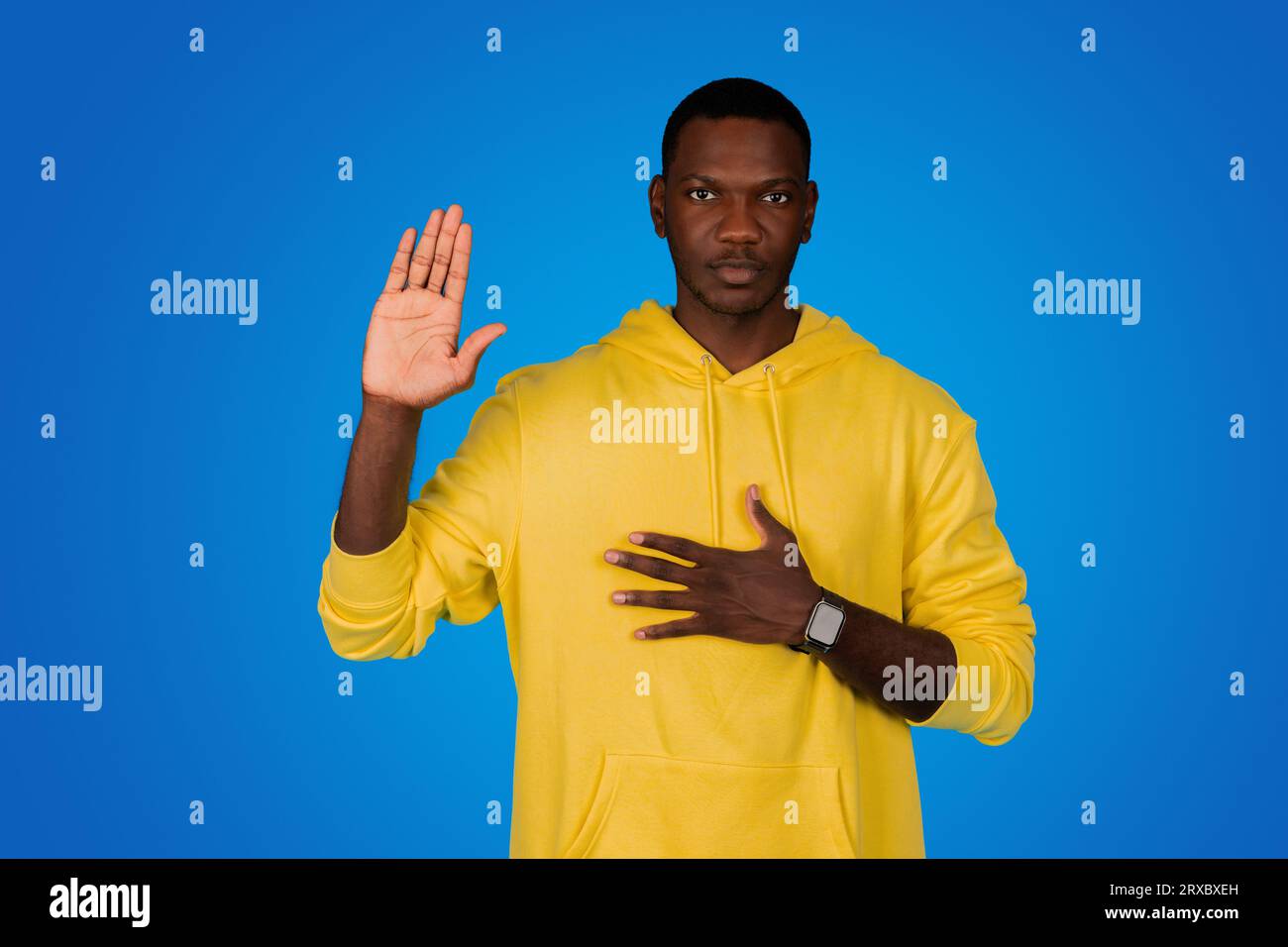 Serious confident strict young black guy presses hand to chest, swears ...