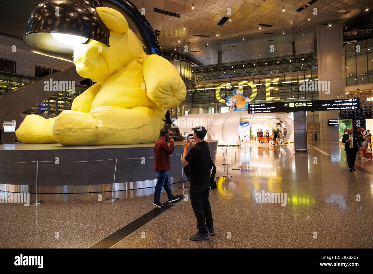 Travellers inspect the Lamp Bear sculpture by Swiss artist Urs Fischer ...