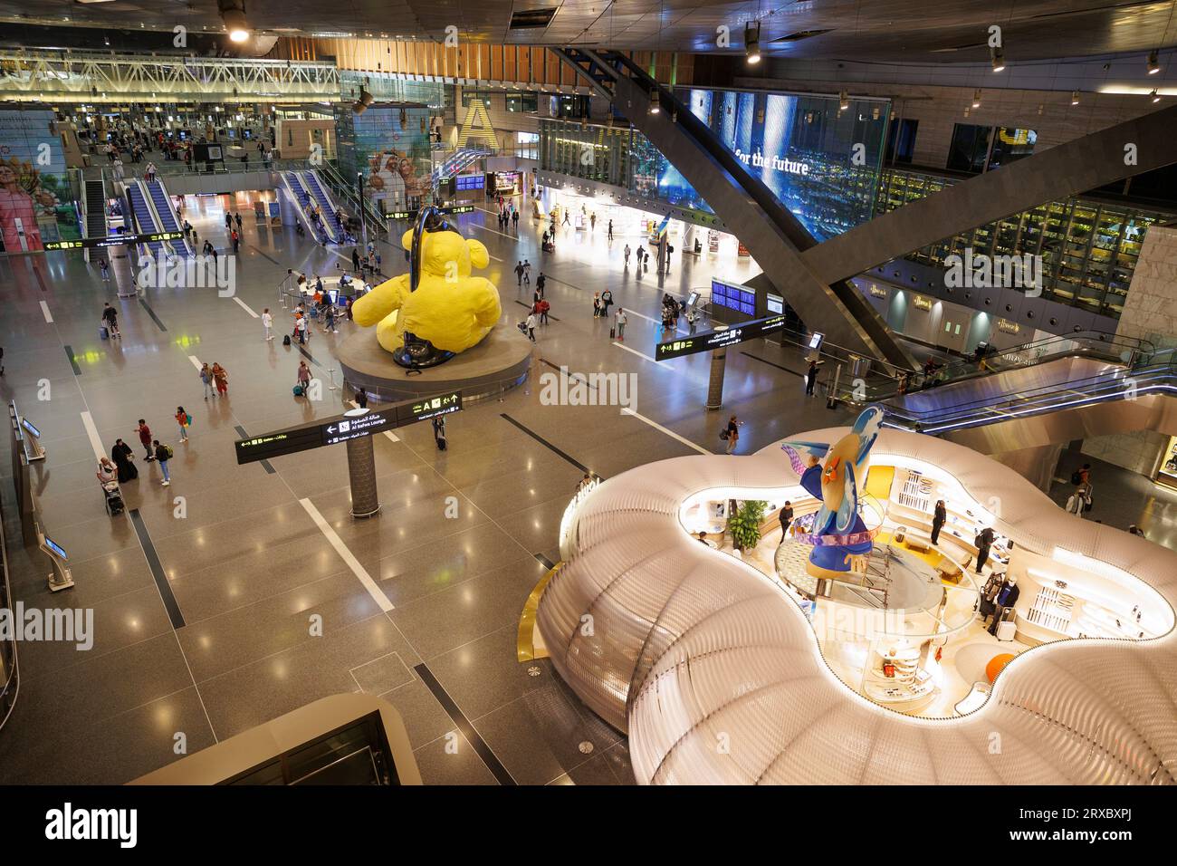 An interior view of Hamad International Airport and Lamp Bear sculpture ...
