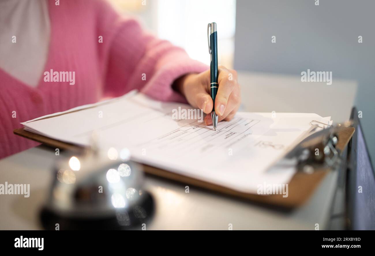 Woman filling form reception desk hi-res stock photography and images ...