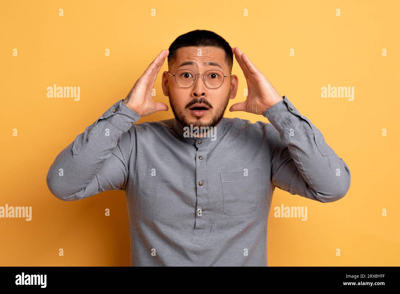 Portrait Of Shocked Young Asian Man Touching Head And Looking At Camera ...