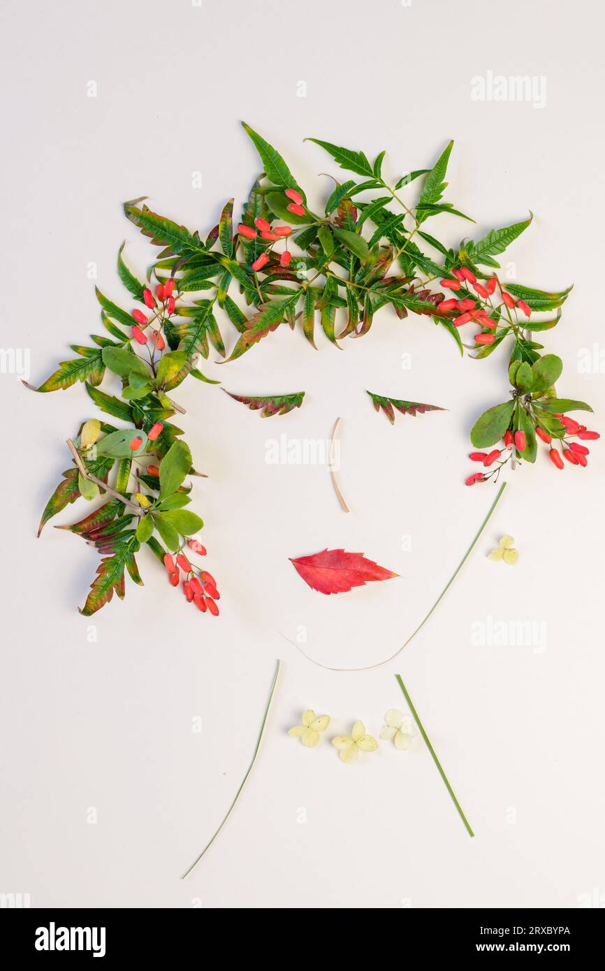 female face made from green autumnal leaves and flowers, isolated on ...