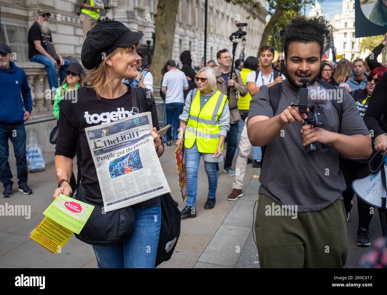 A woman distributes the conspiracy theorist newspaper "The Light" and ...