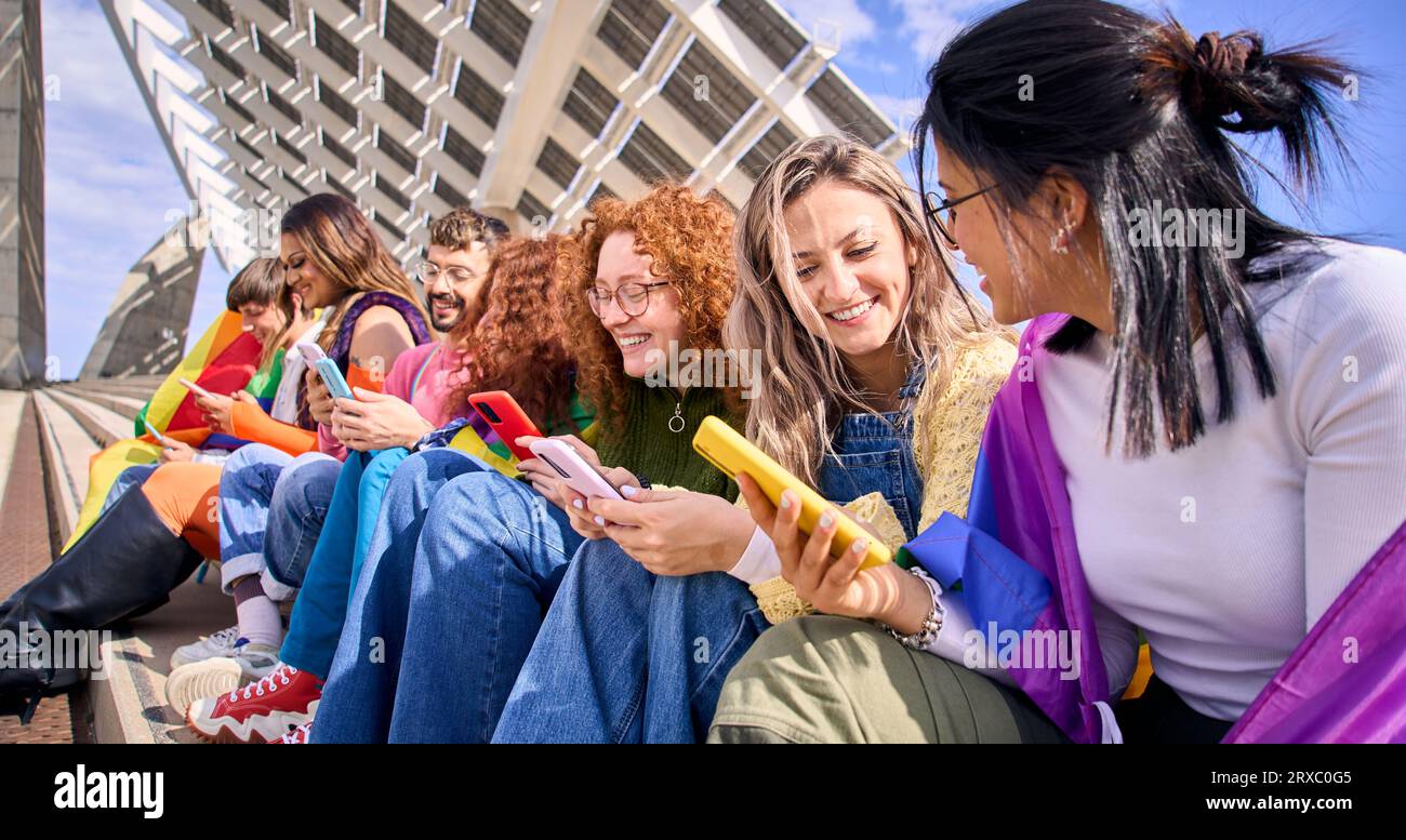 Side view large multiracial group young friends using cell phones ...