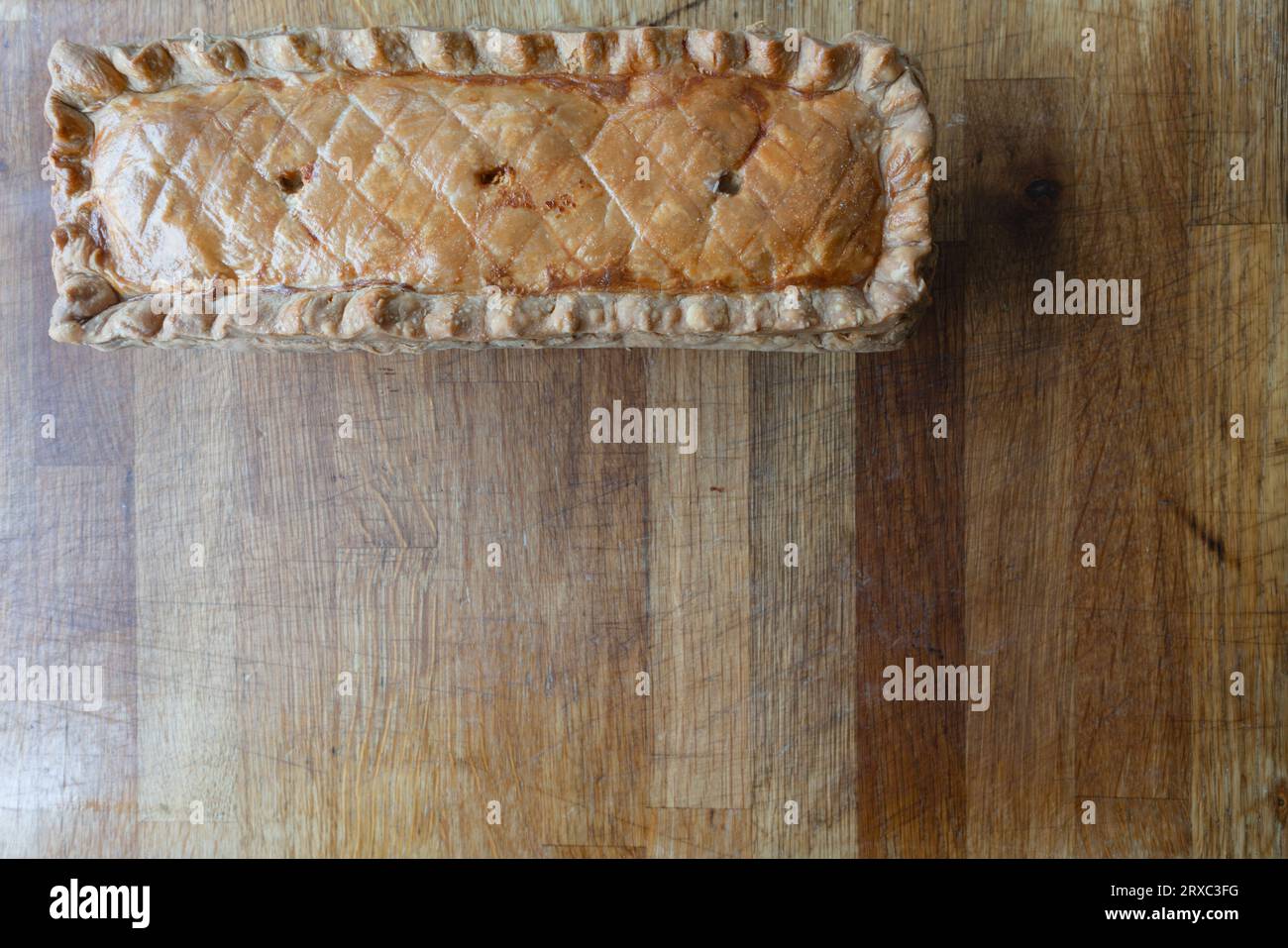 Before being baked, a Gala Pie rests on a wooden block Stock Photo - Alamy