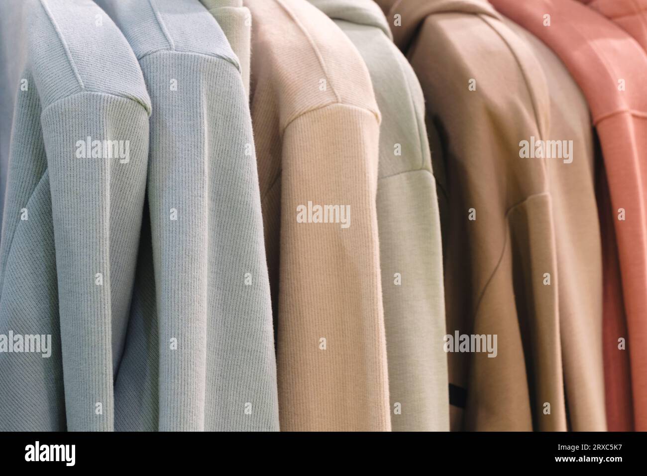 Fashion hoodie clothes on clothing rack Closeup of rainbow color choice ...