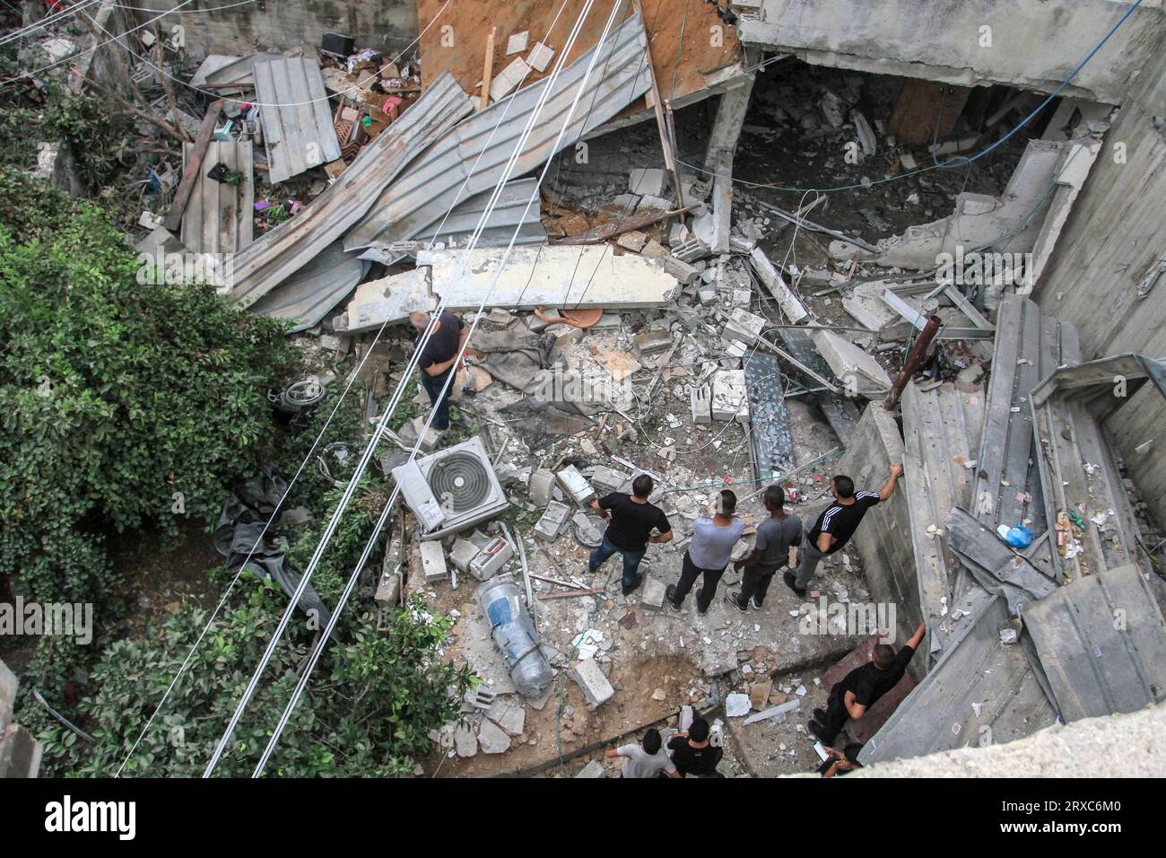 Palestinians inspect the damaged building caused by the Israeli army ...